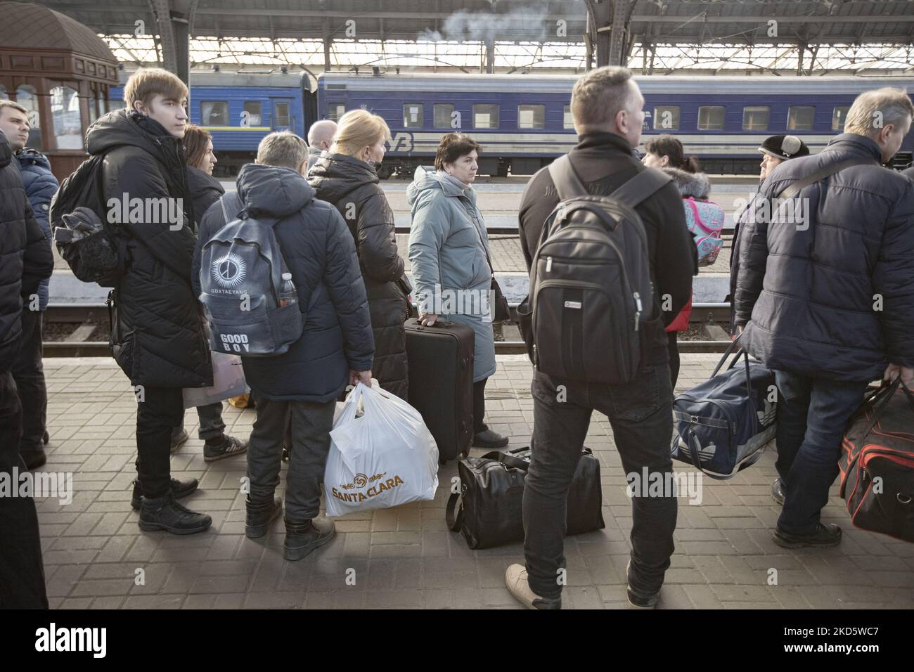 People wait for the train. When the train arrives they move fast to get ...