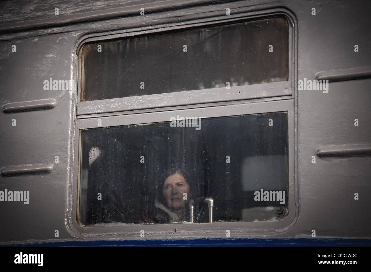 A woman. People as seen through the train wagon window, waiting for ...