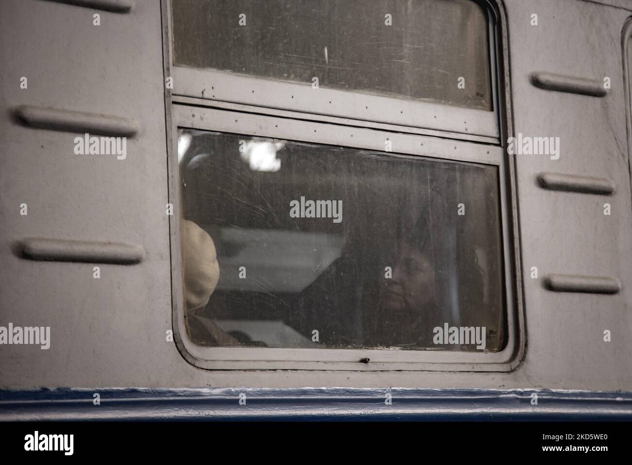 A woman, people as seen through the train wagon window, waiting for ...