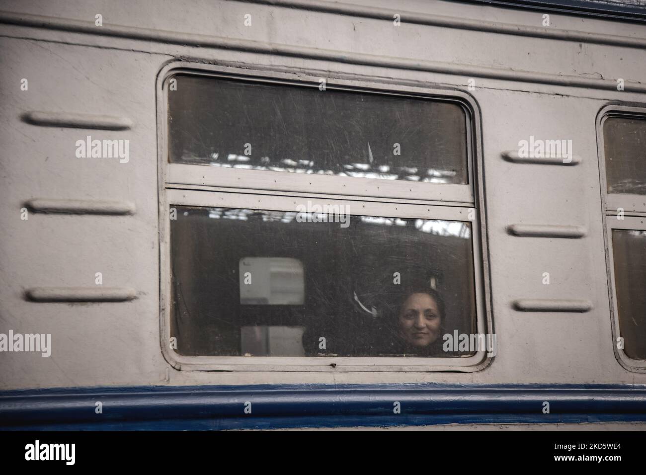A young woman, people as seen through the train wagon window, waiting ...