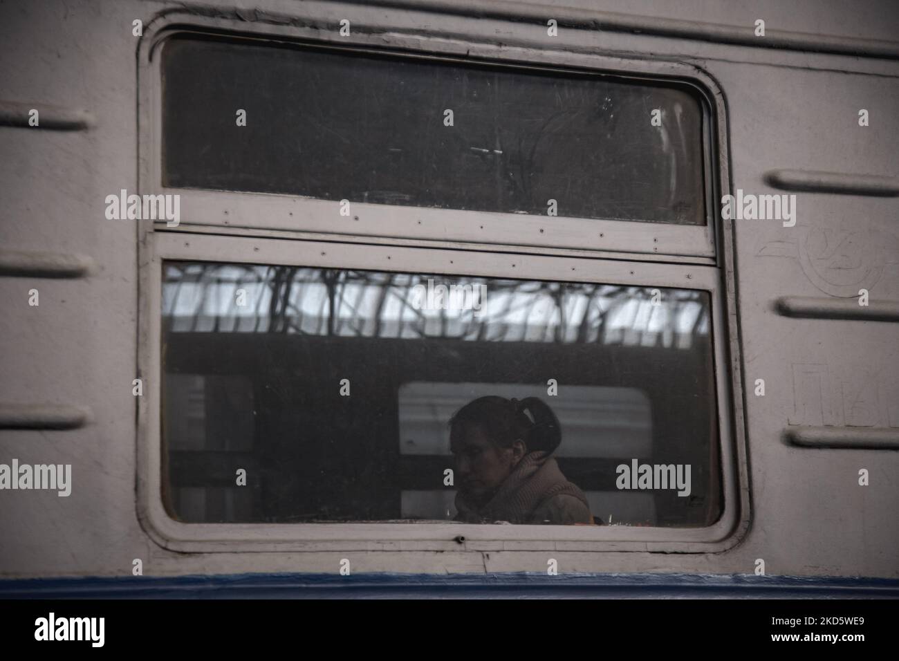 A woman, people as seen through the train wagon window, waiting for ...