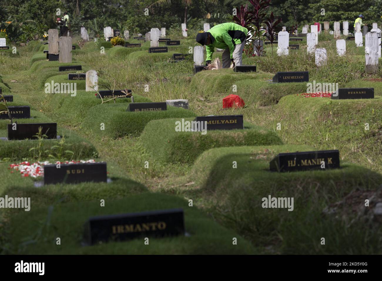 Officers clean the COVID-19 graveyard in Srengsesngsawah, South Jakata ...