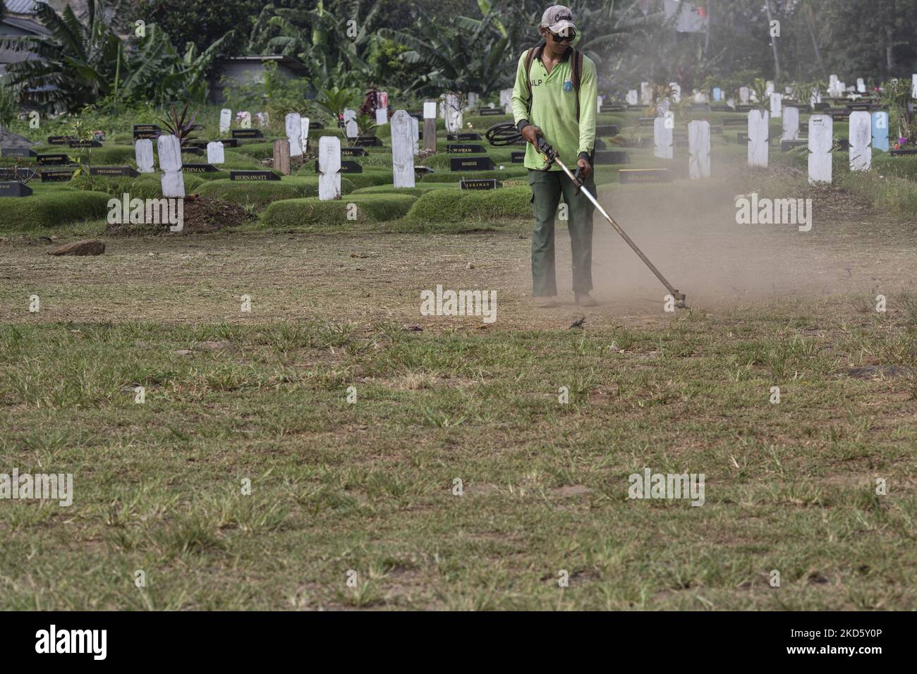Officers clean the COVID-19 graveyard in Srengsesngsawah, South Jakata ...