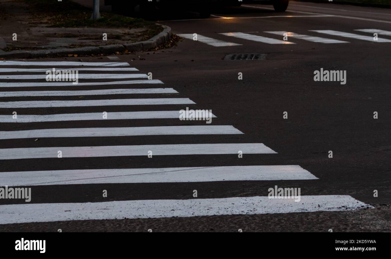 White stripes of pedestrian crossing. Focus at the center of image ...
