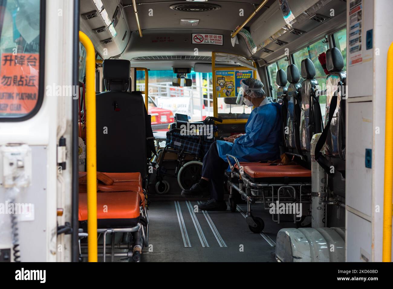 A paramedic checks his phone while waiting in an ambulance bus to ...