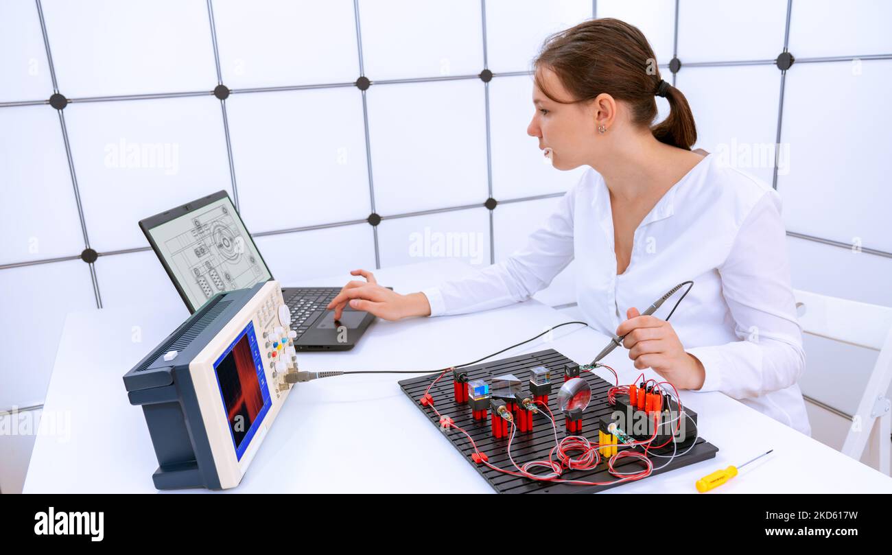 young woman student is experimenting with a laser measurement system ...