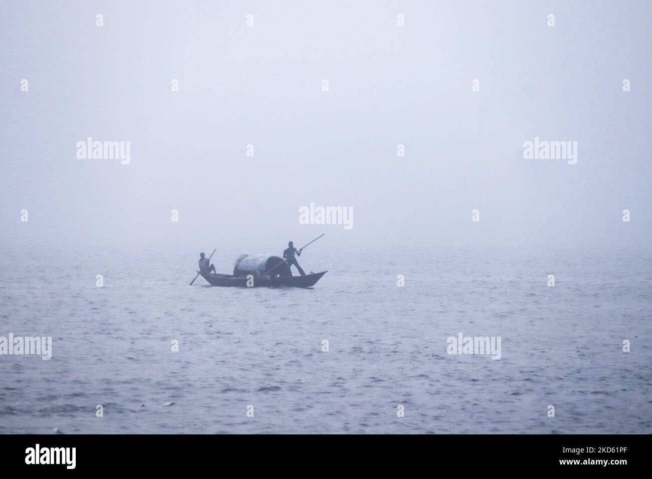 Fishermen paddle their boat during a sand storm in the Brahmaputra ...