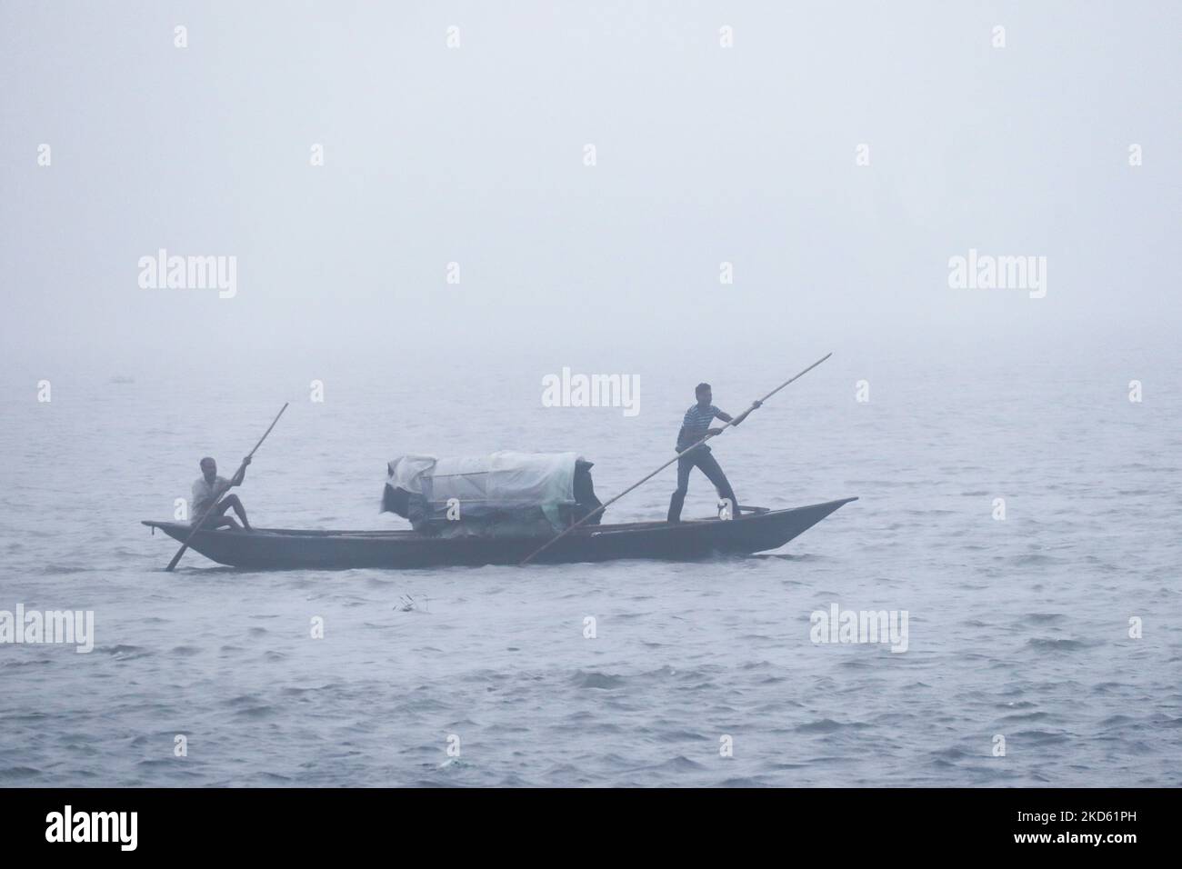 Fishermen paddle their boat during a sand storm in the Brahmaputra ...