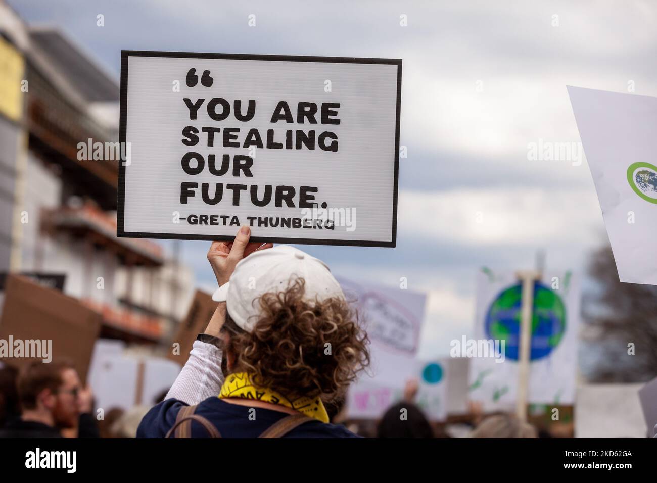 A protester carries a sign with a quote from Greta Thunberg during a ...