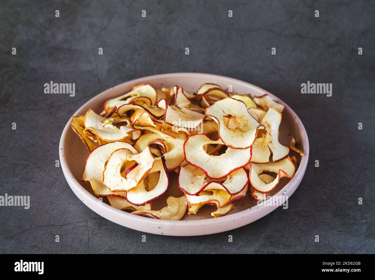 Homemade dried organic apple sliced chips in plate. Healthy snacks ...