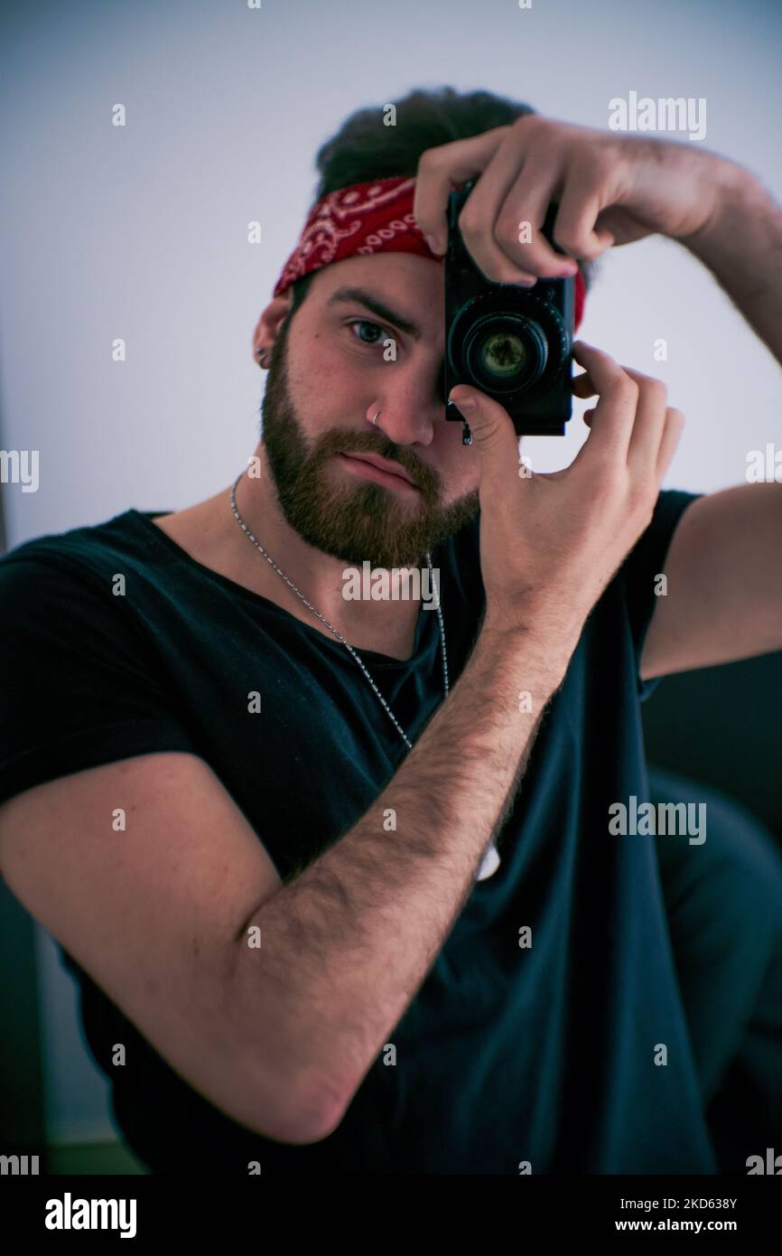 A vertical shot of a young Caucasian man with a red bandana taking a ...