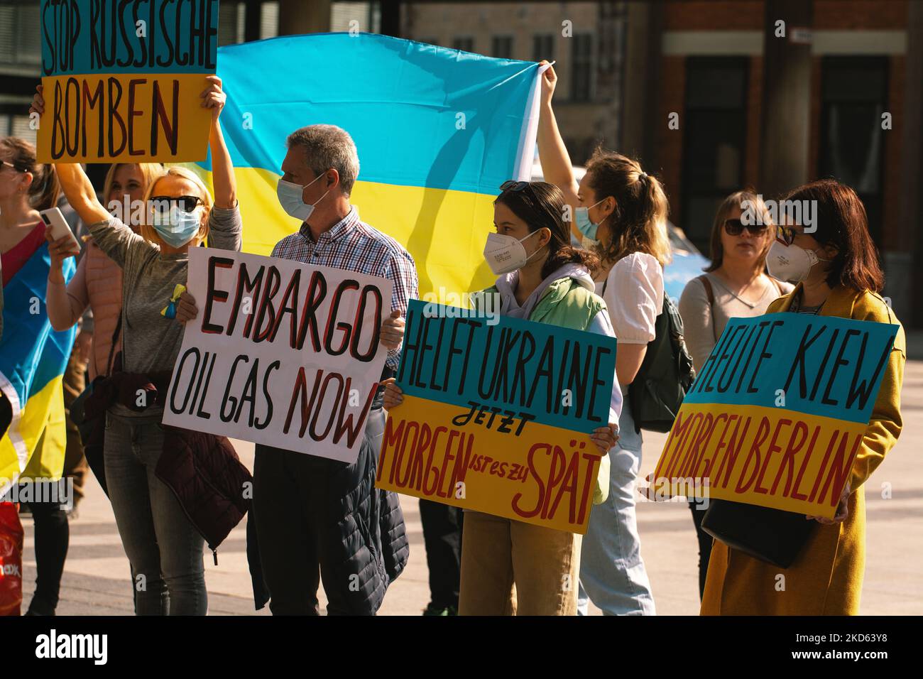 Protesters hold the signs " embargo oil and gas now" , "help Ukraine ...