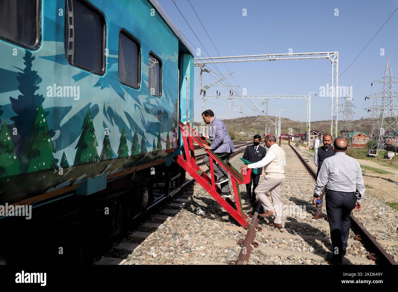 Workers are seen during Electric Train Run at Baramulla Railway Station ...
