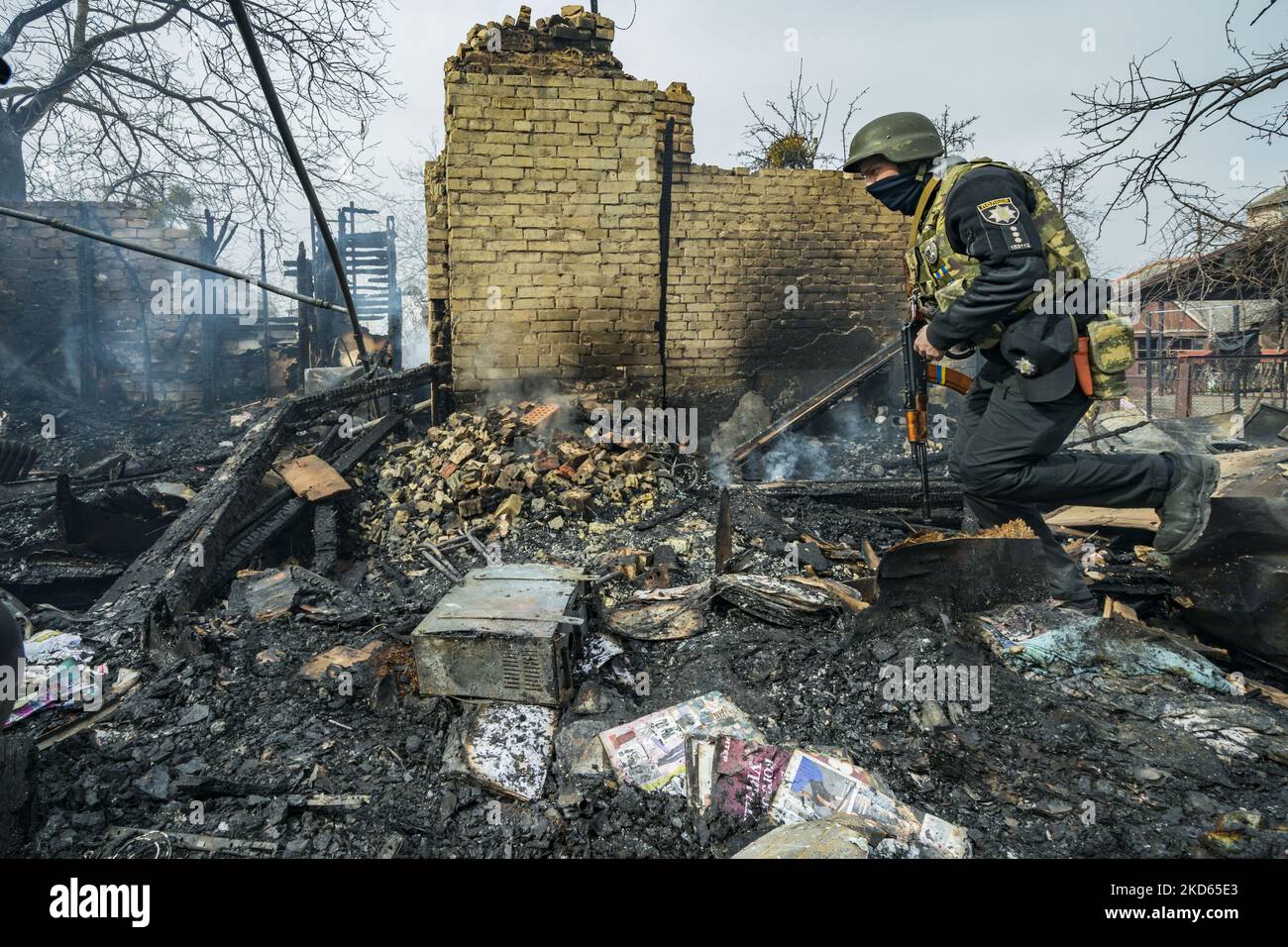 Ukrainian police checks a house in ruins by fire after the strikes of ...