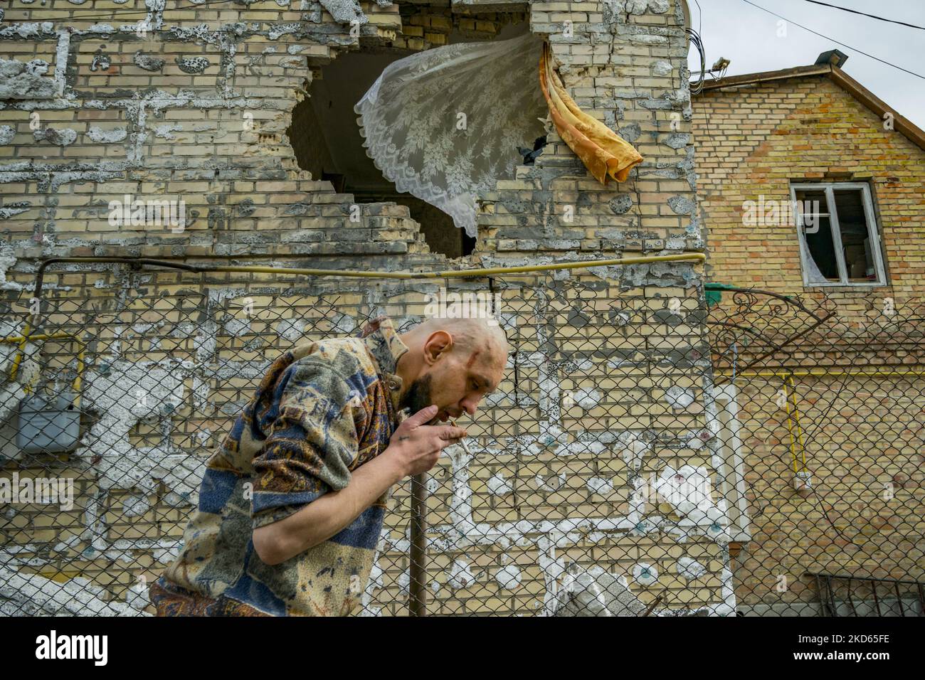 A man passes under a damaged building by rockets of the russian ...