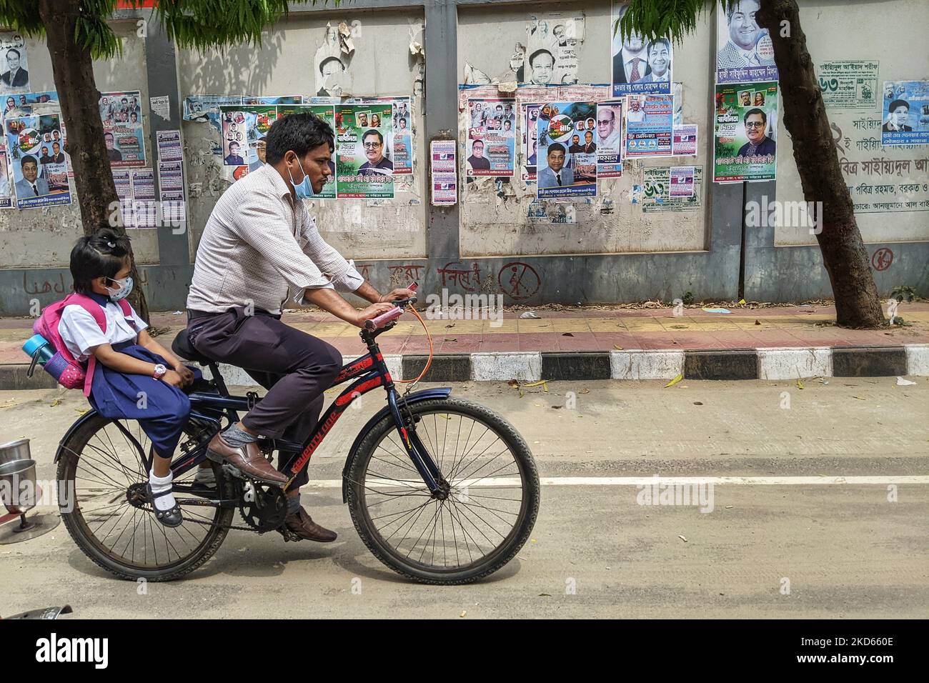 Father taking his child to school on a bicycle in Dhaka, Bangladesh on ...