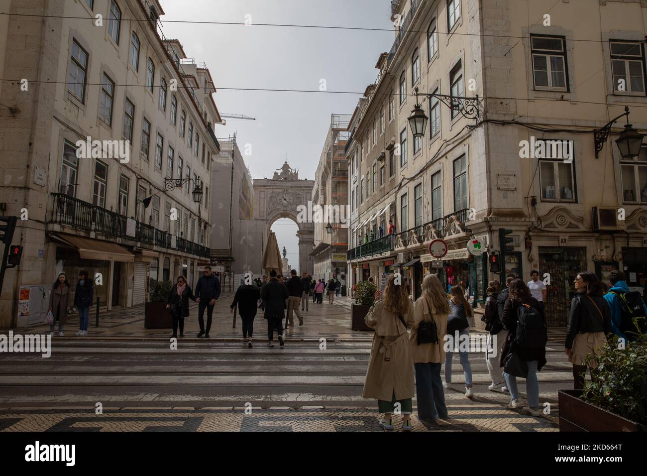 People walk in the historic center of Lisbon near the Arco da Rua ...