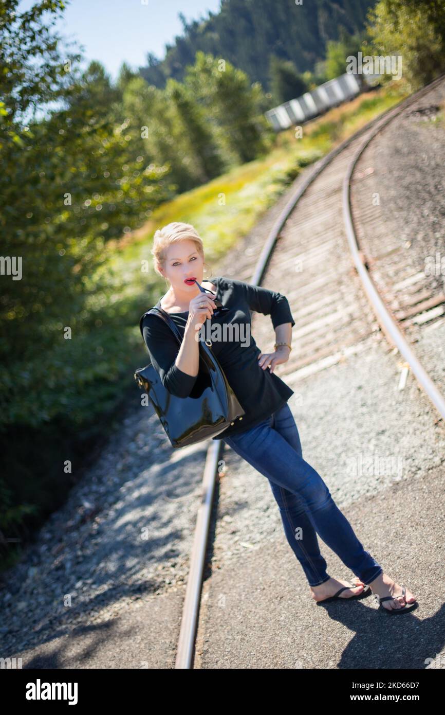 Pretty woman at the railroad tracks Stock Photo - Alamy