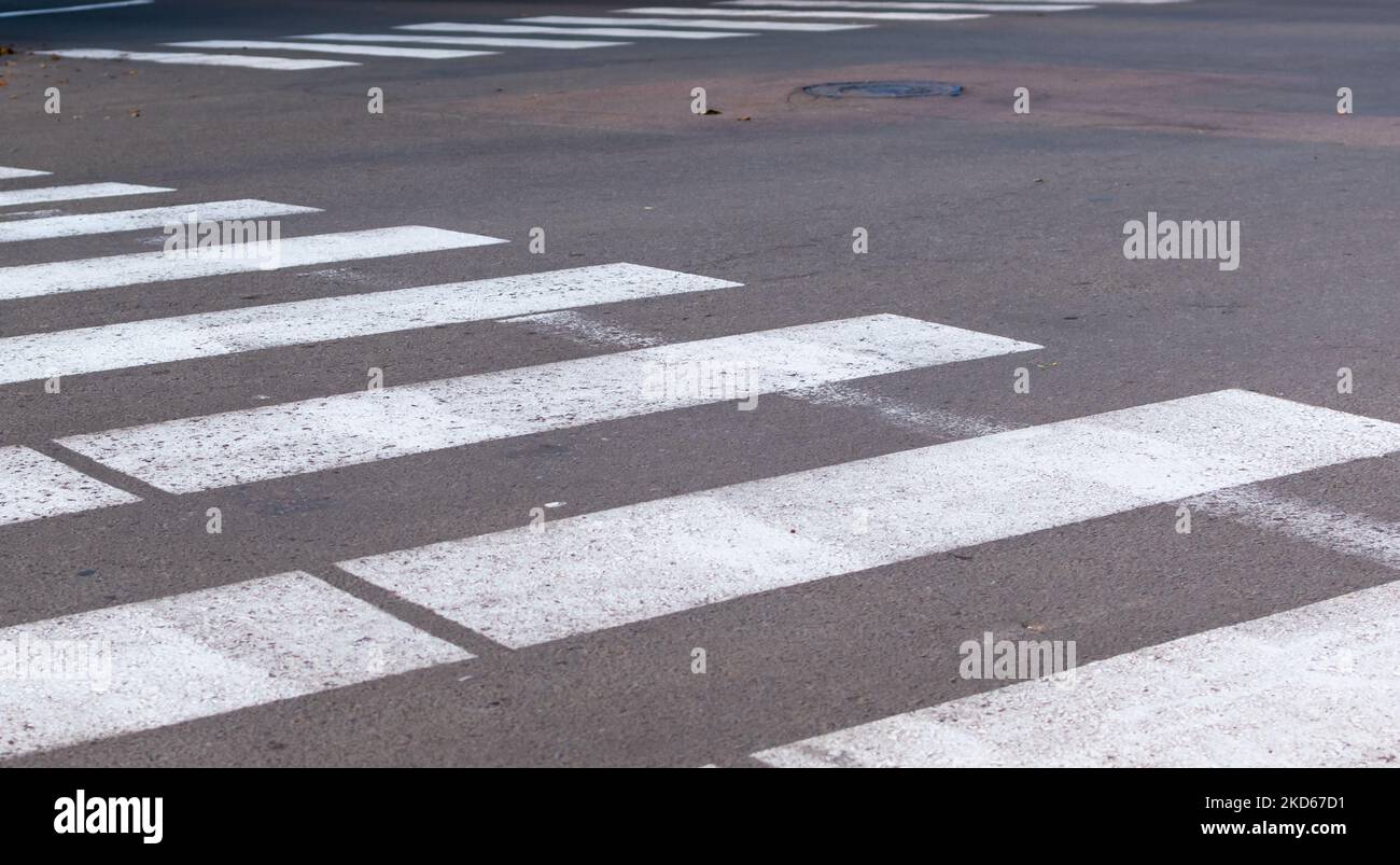 White stripes of pedestrian crossing. Focus at the center of image ...