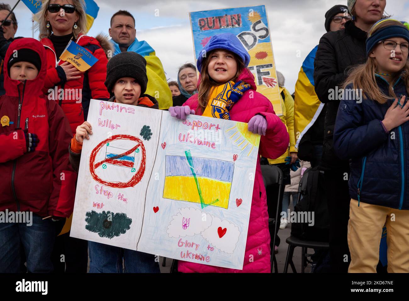 Children display their homemade sign during a rally marking the one ...