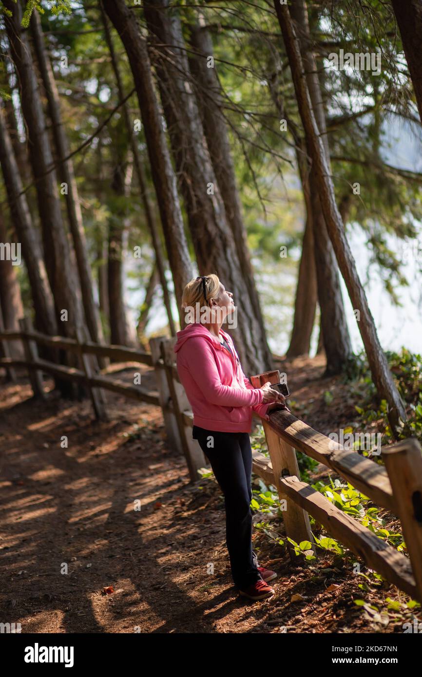 Pretty woman hiking on a forest trail with trees Stock Photo - Alamy