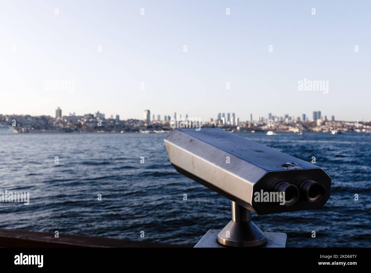 Binoculars close up. A ship on a river or sea sails out of the port ...