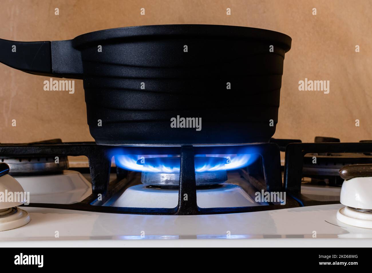 Black metal pot on gas stove close-up on blurred kitchen background ...