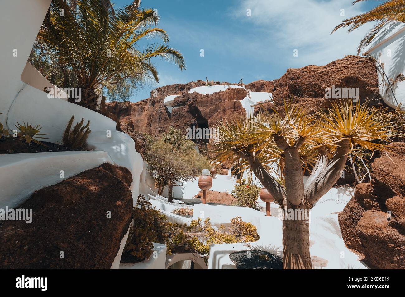 A low angle shot of a white resort building with palm trees in Mallorca ...