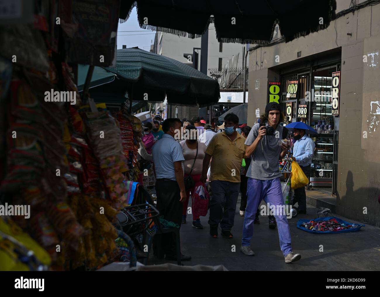 A local street photographer is walking down a busy street in downtown ...