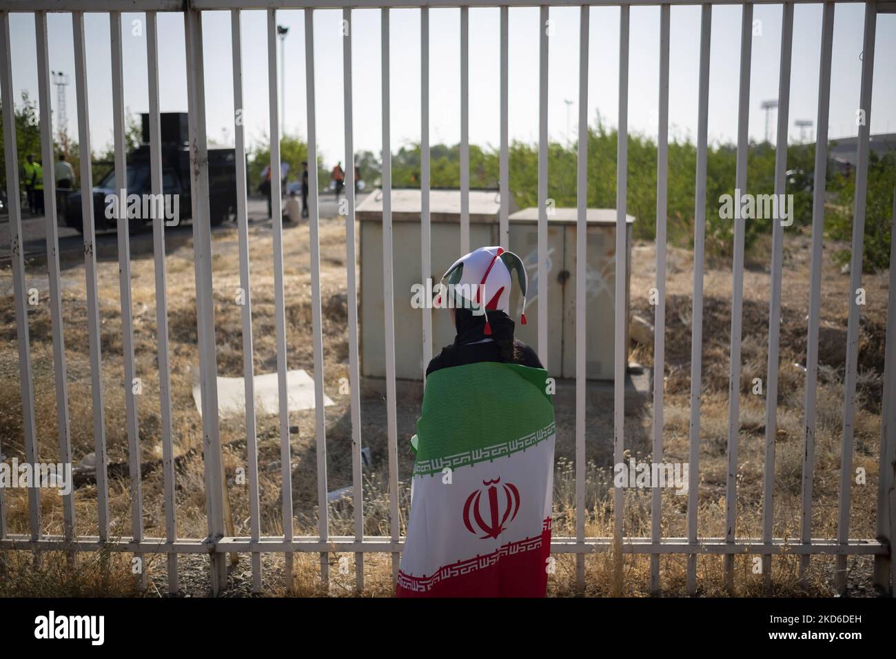 An Iranian soccer female fan wearing a hat and an Iran flag as she ...