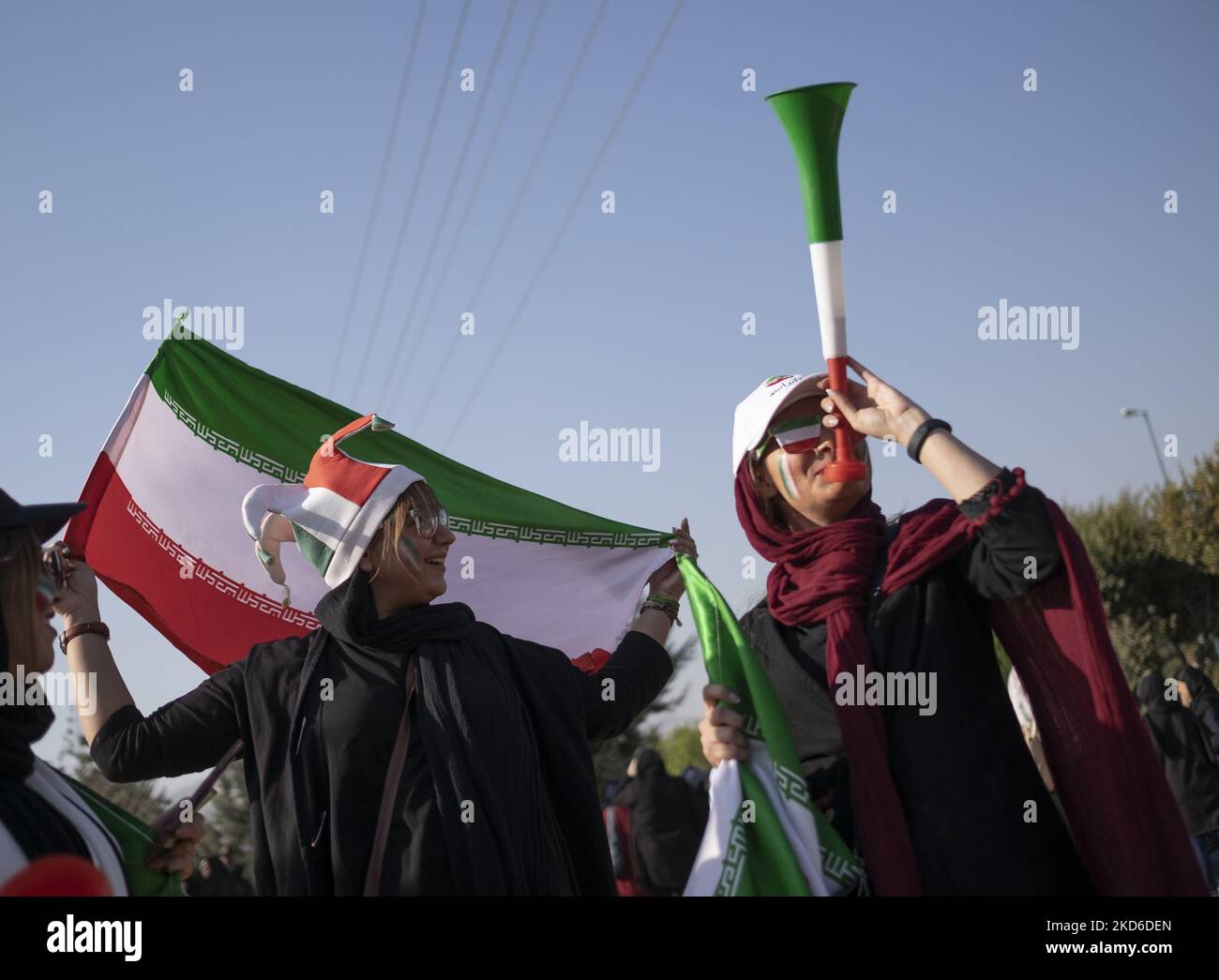 An Iranian soccer female fan holds an Iran flag as the other one plays ...