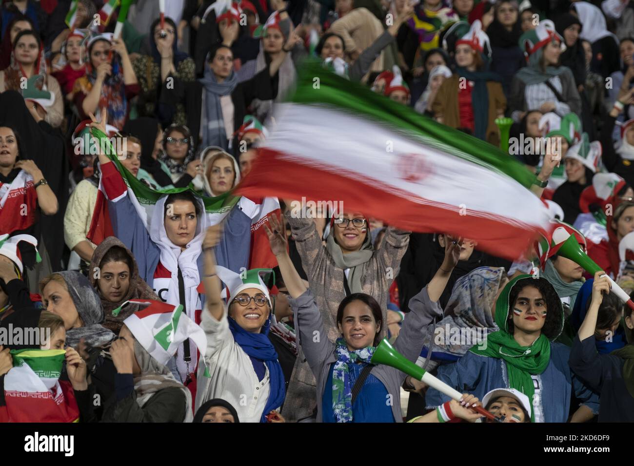 An Iranian soccer female fan waves an Iran flag as she stands at the ...