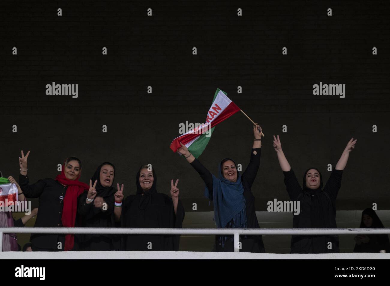 An Iranian soccer female fan waves an Iran flag as the others flash ...