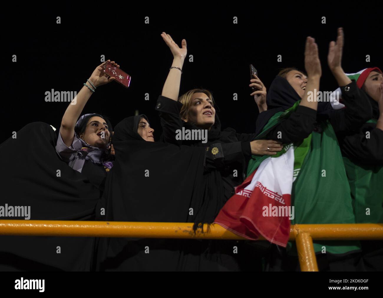 A policewoman controls Iranian soccer female fans at the Azadi (Freedom ...