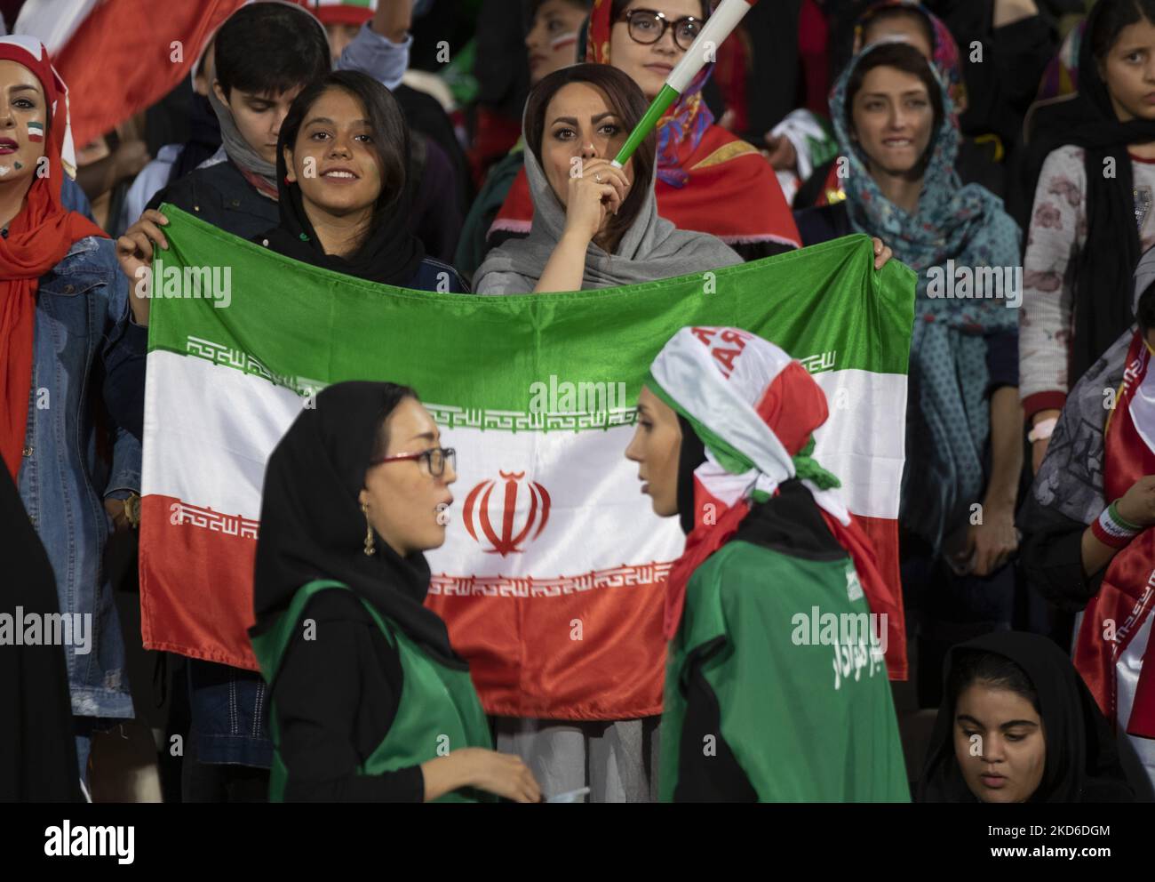 Iranian soccer female fans play horn and hold an Iran flag at the Azadi ...