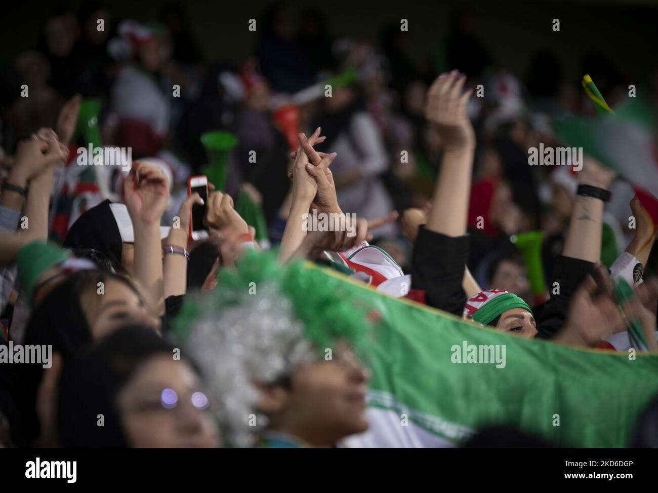 Two Iranian soccer female fans hold-up their hands as a sign of unity ...