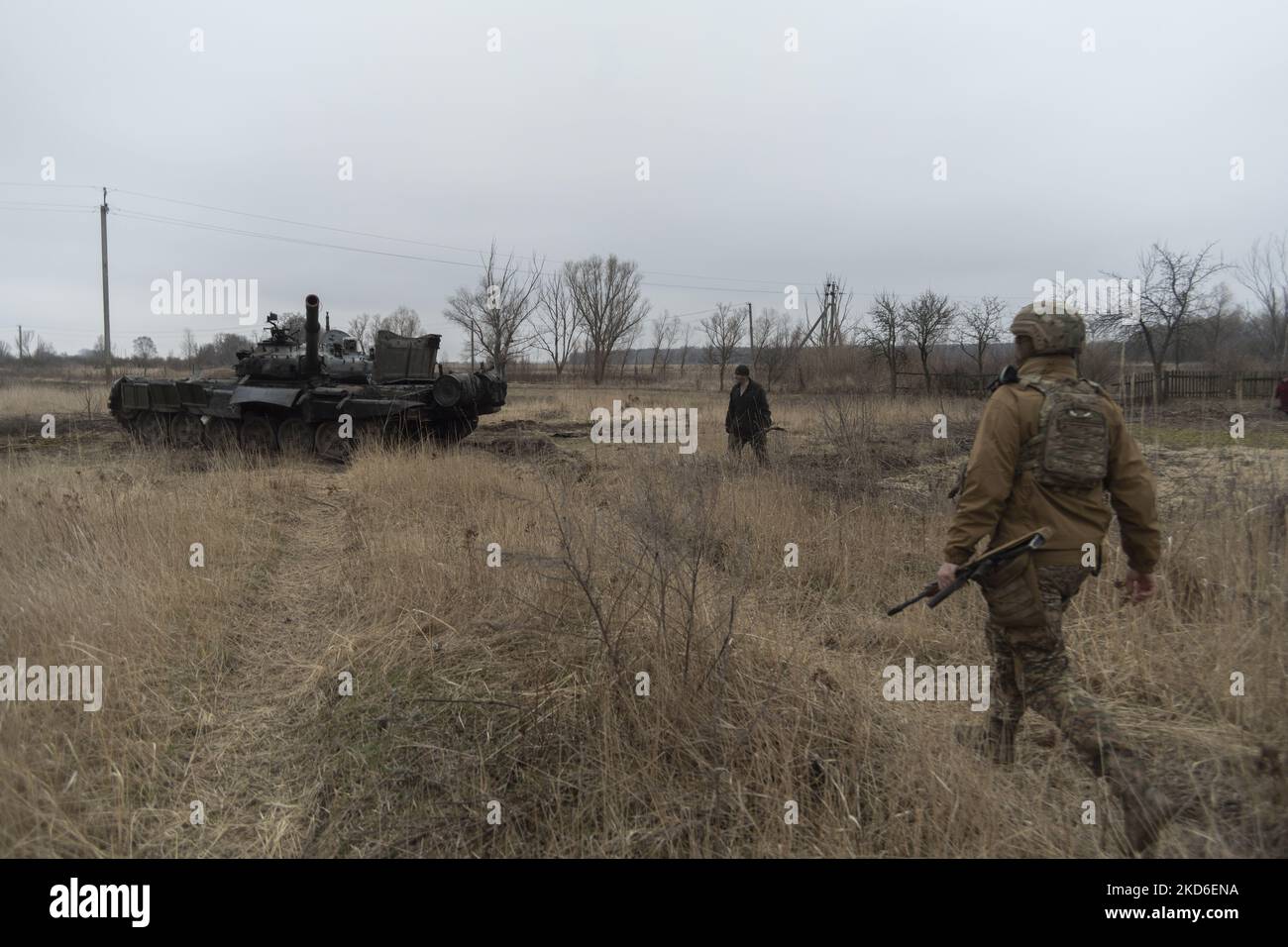Ukrainian soldier walks towards a destroyed Russian tank, on March 31 ...