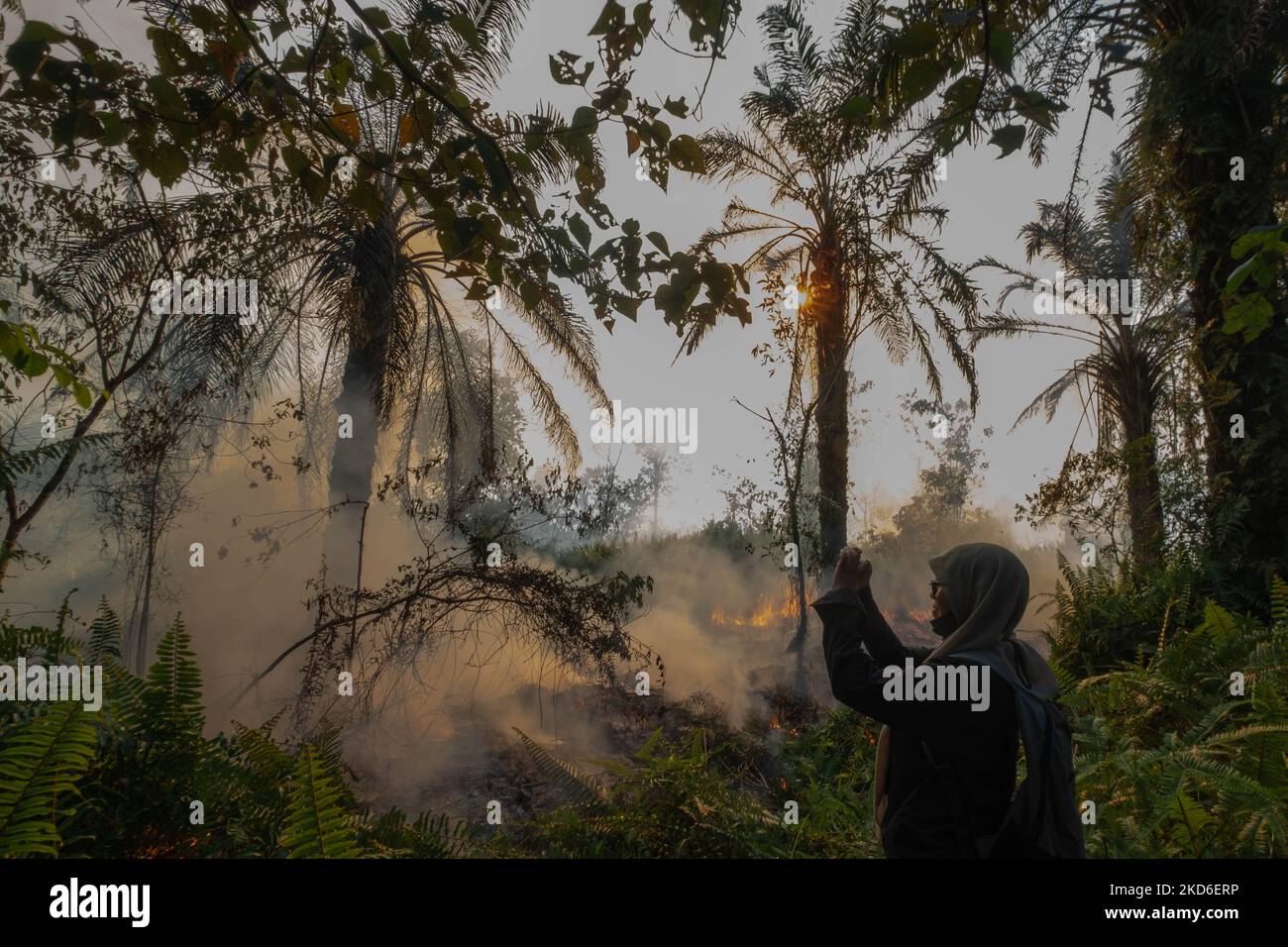 A women take picture a burning peat-land in Kampar, Riau Province, Indonesia. (Photo by Afrianto ...