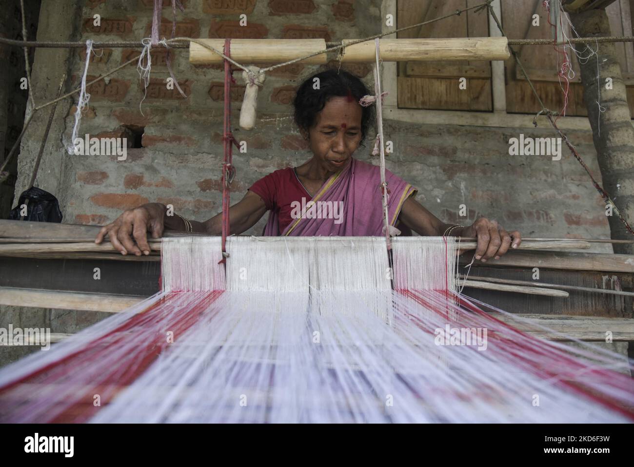 An Assamese woman weaves Assamese Traditional Gamosa (scarf) in ...