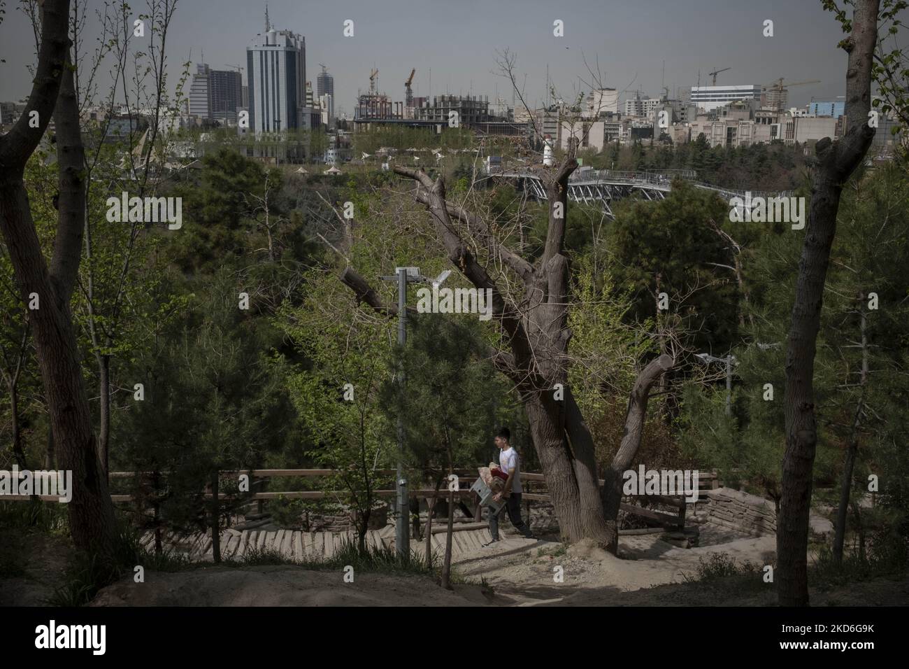 An Afghan refugee man carrying a fire-pan in a park in northern Tehran ...