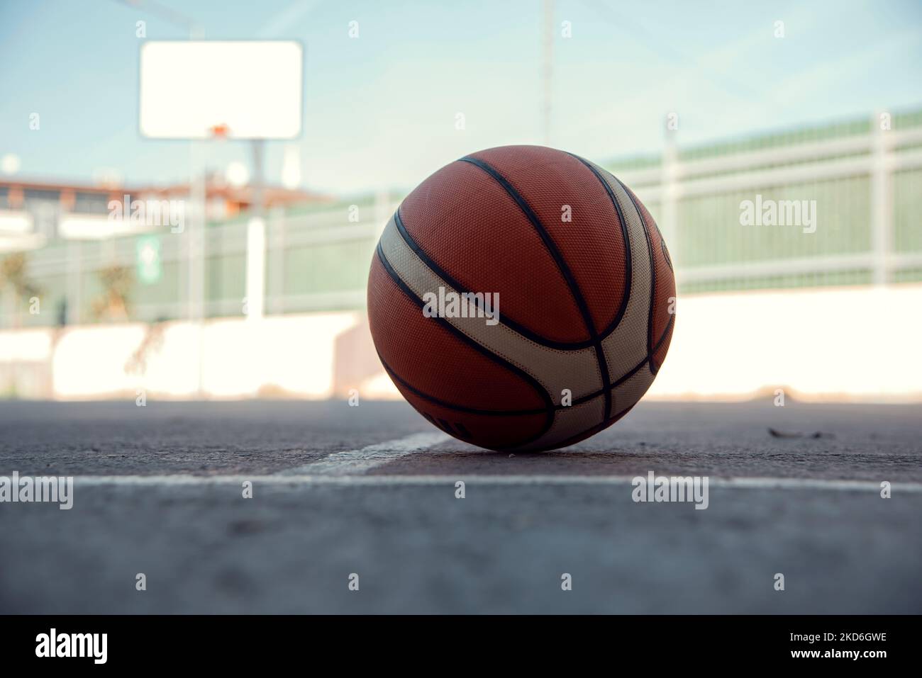 An orange basketball with stripes on a basketball court Stock Photo - Alamy