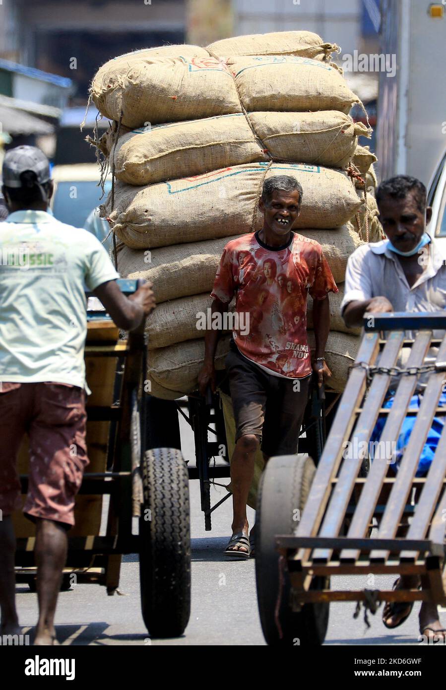 A Sri Lankan daily wage worker pushes a cart at the main local market ...