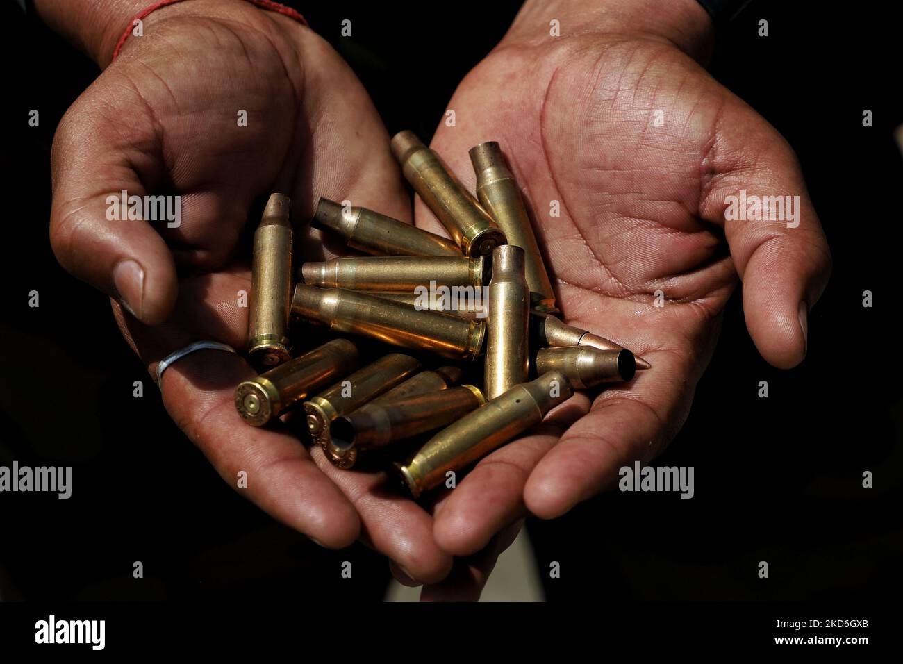 An Indian army soldier shows bullet cartridges after a practice session ...