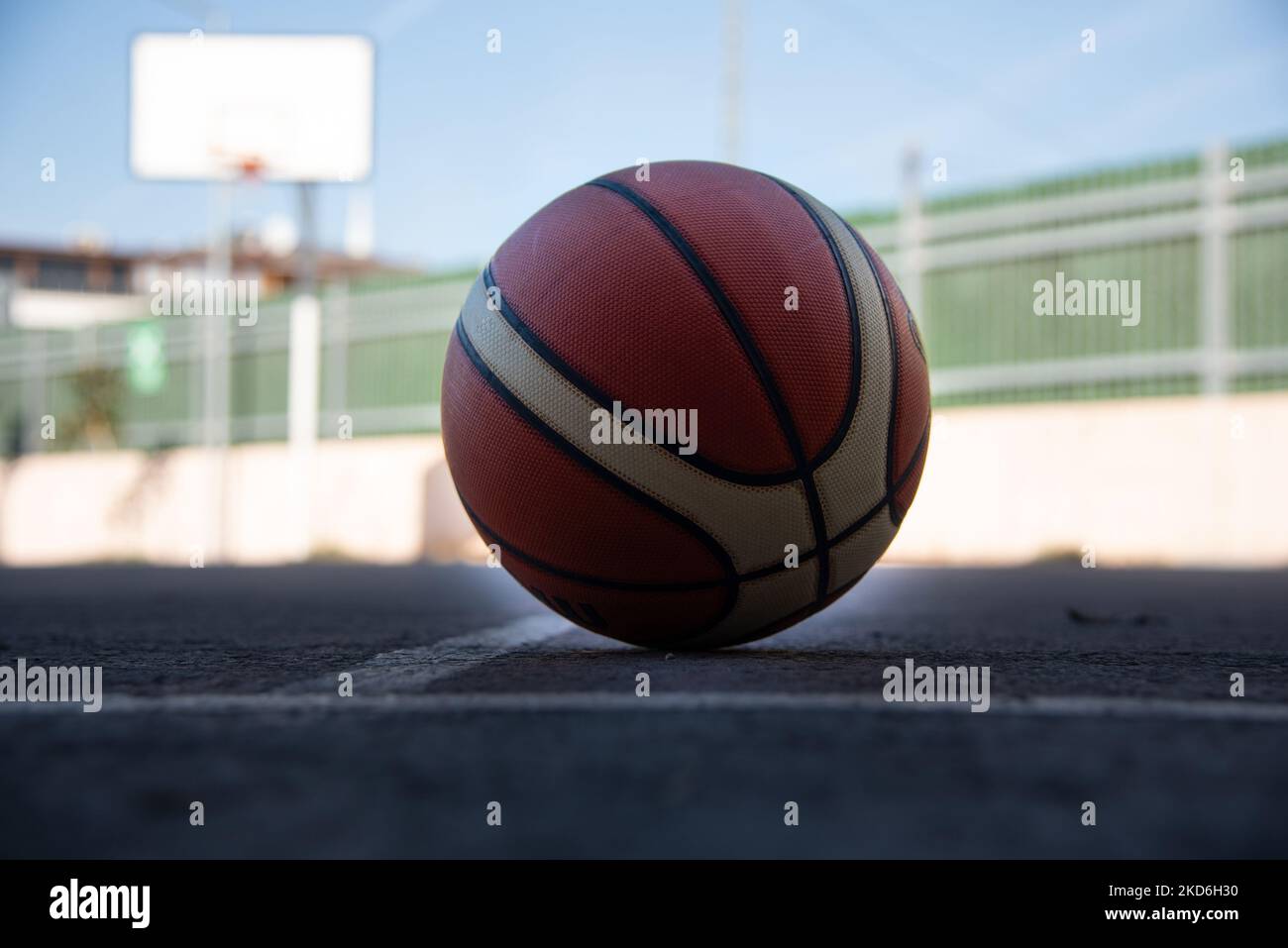 An orange basketball with stripes on a basketball court Stock Photo - Alamy