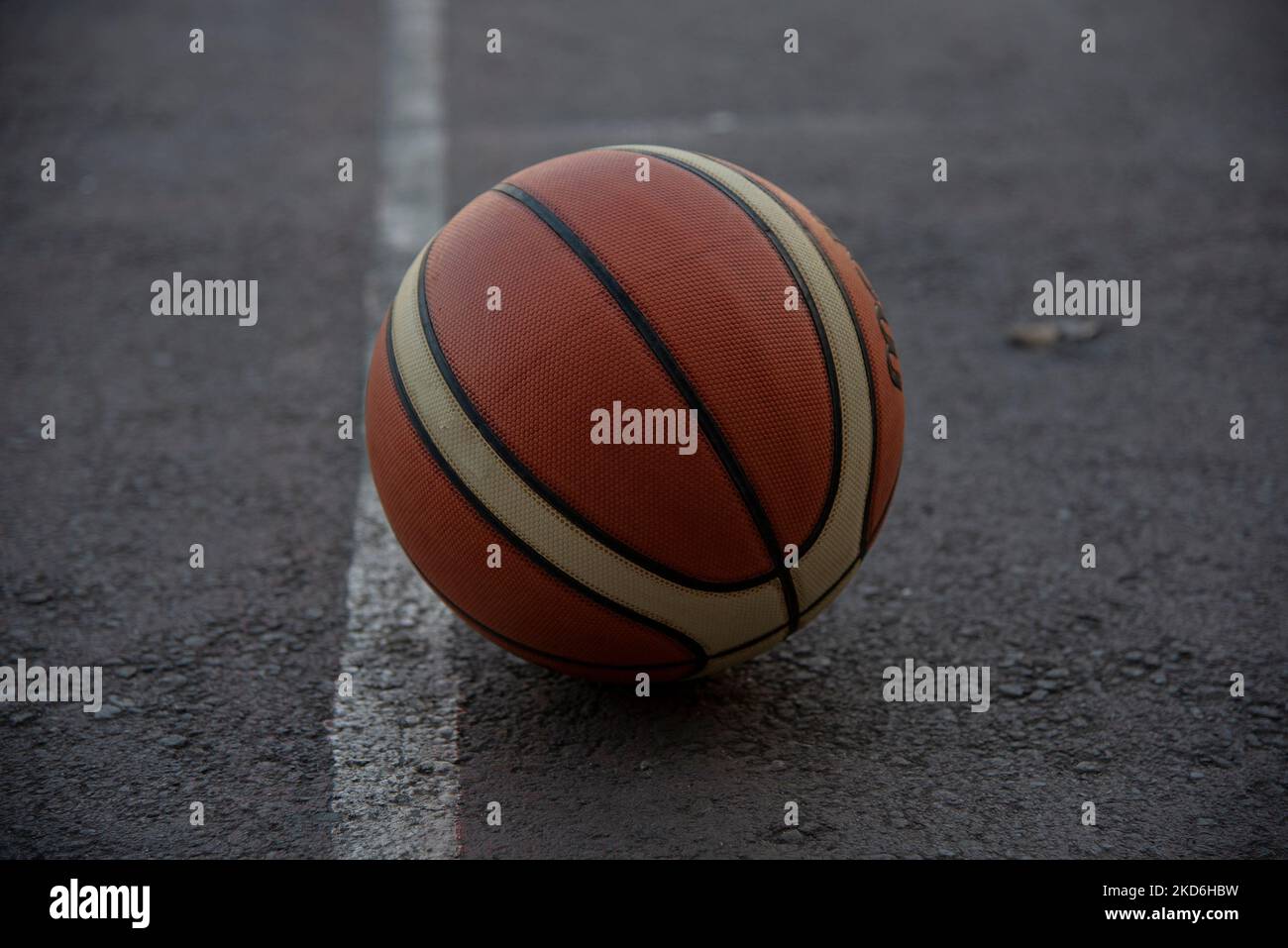 An orange basketball with stripes on a basketball court Stock Photo - Alamy