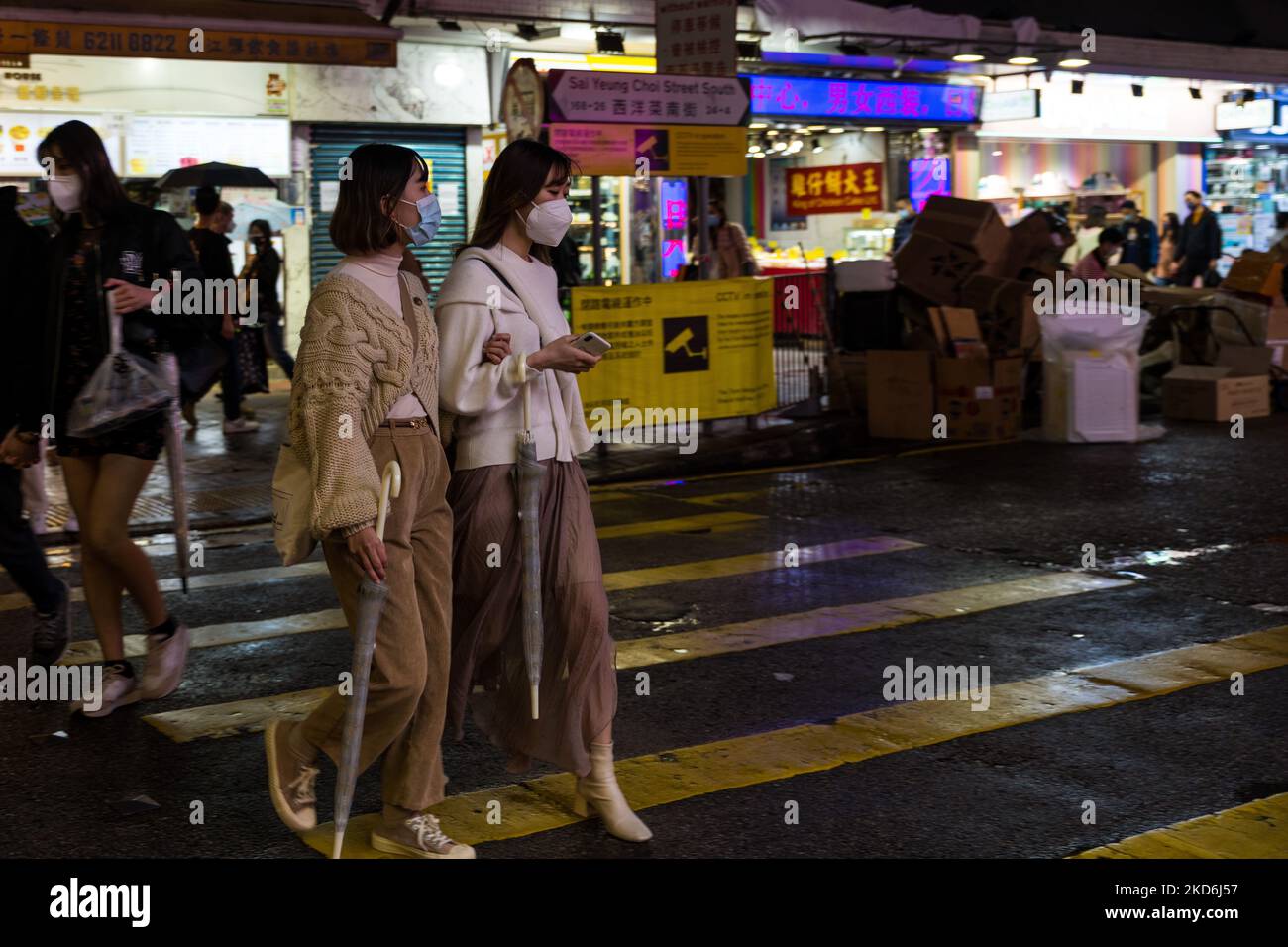 Hong Kong, China, 2 Apr 2022, Two masked young ladies cross Sai Yeung ...