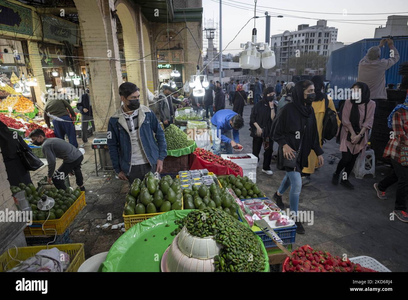 Iranian people wearing protective face masks walk past the Tajrish ...