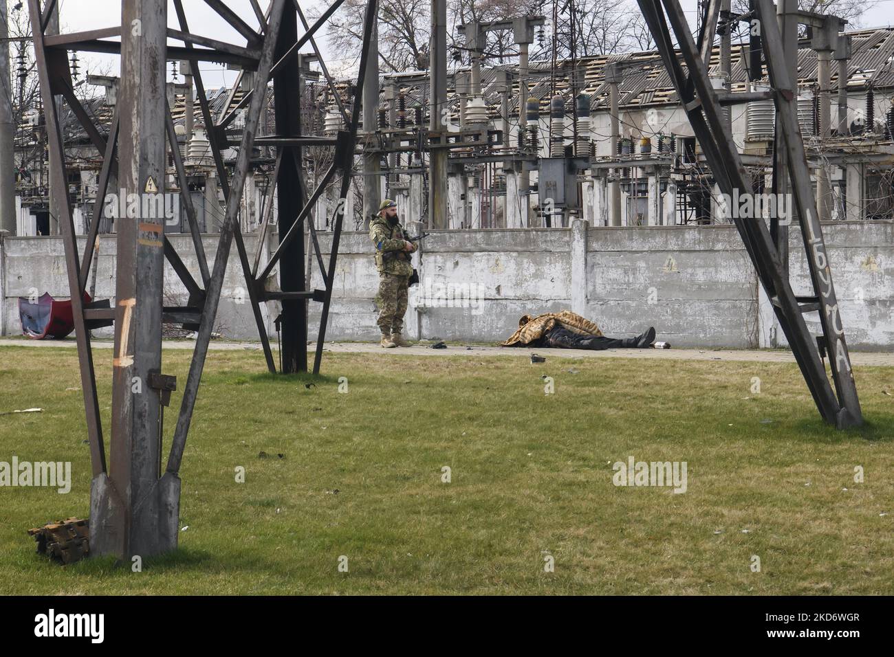 Ukrainian serviceman stands near a body of civilian in the recaptured ...