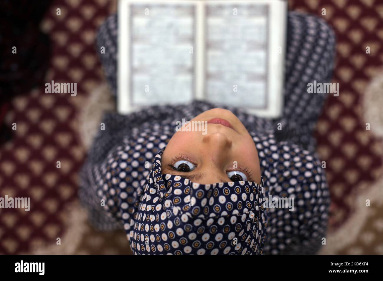 A Palestinian girl studies the holy Koran at a mosque during the Muslim ...