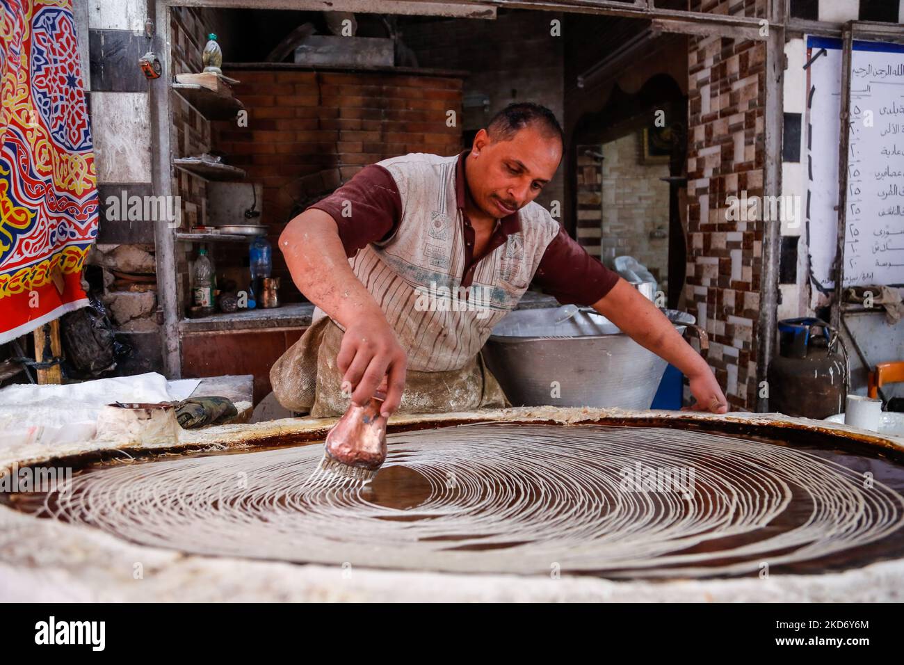An Egyptian baker prepares 'Kanafeh', a traditional Middle Eastern ...